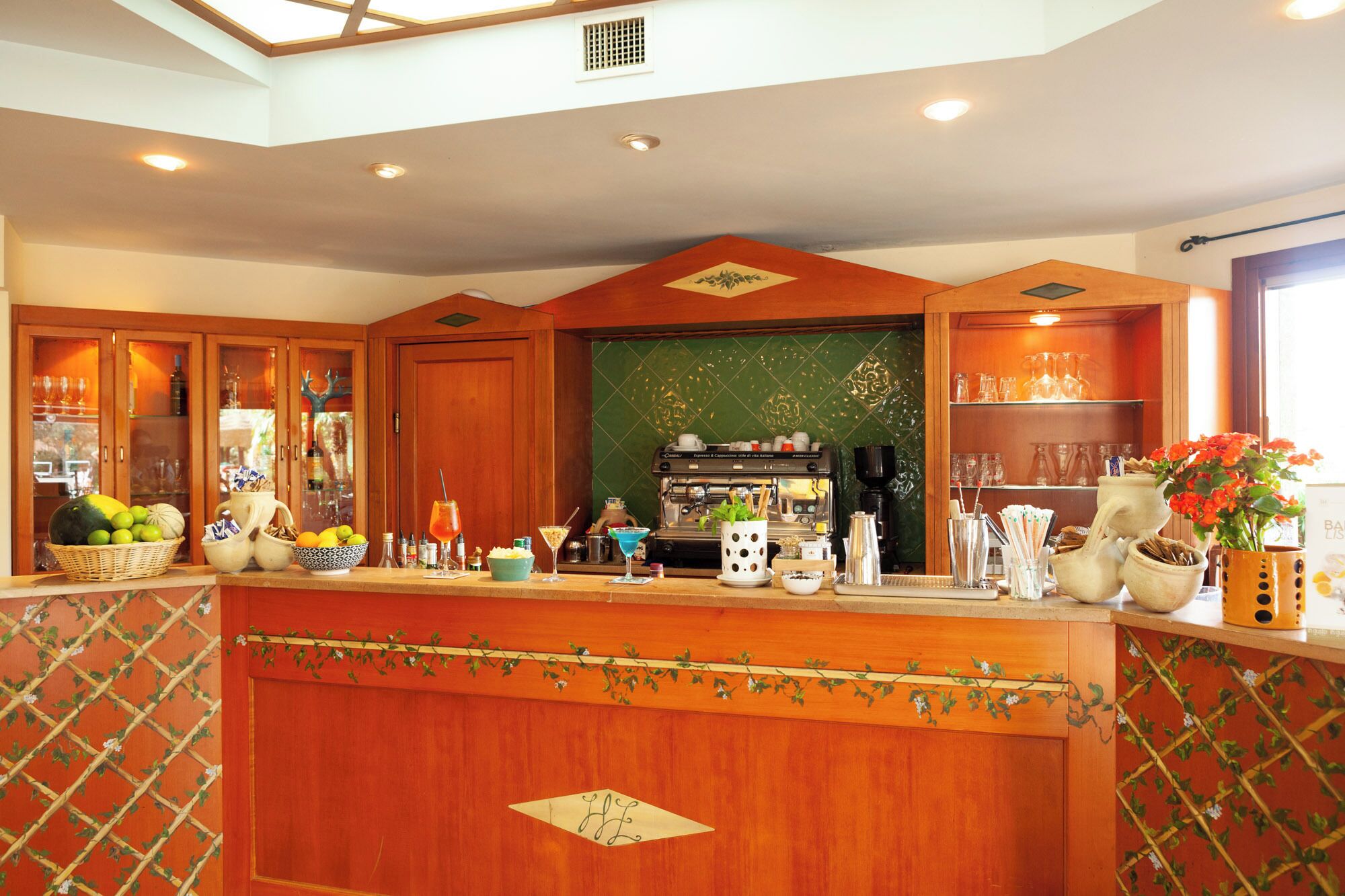 Uma área de bar com uma máquina de café, utensílios de bar e uma planta decorativa.