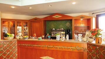 Uma área de bar com uma máquina de café, utensílios de bar e uma planta decorativa.