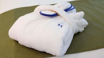 Uma sacola branca e fofa, com alça azul e um pequeno logo azul sobre uma superfície verde.