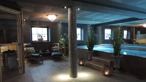 Um lobby amplo com um grande pilar, área de estar e piscina.