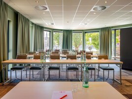 Uma sala de conferências com mesas, cadeiras e vista para a cidade.