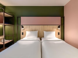 Um quarto com beliches, cabeceira de madeira e luminárias de cabeceira.