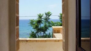 Varanda com vista para o mar e uma árvore.