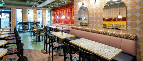 Um restaurante com cabines, mesas e cadeiras.