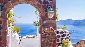 Um arco que dá acesso a um hotel com vista para o mar.