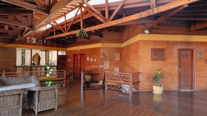 Um quarto amplo com vigas de madeira, parede de tijolo e piso de madeira.