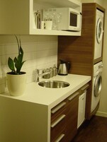 Um frigorífico, um micro-ondas, uma cafeteira/bule 