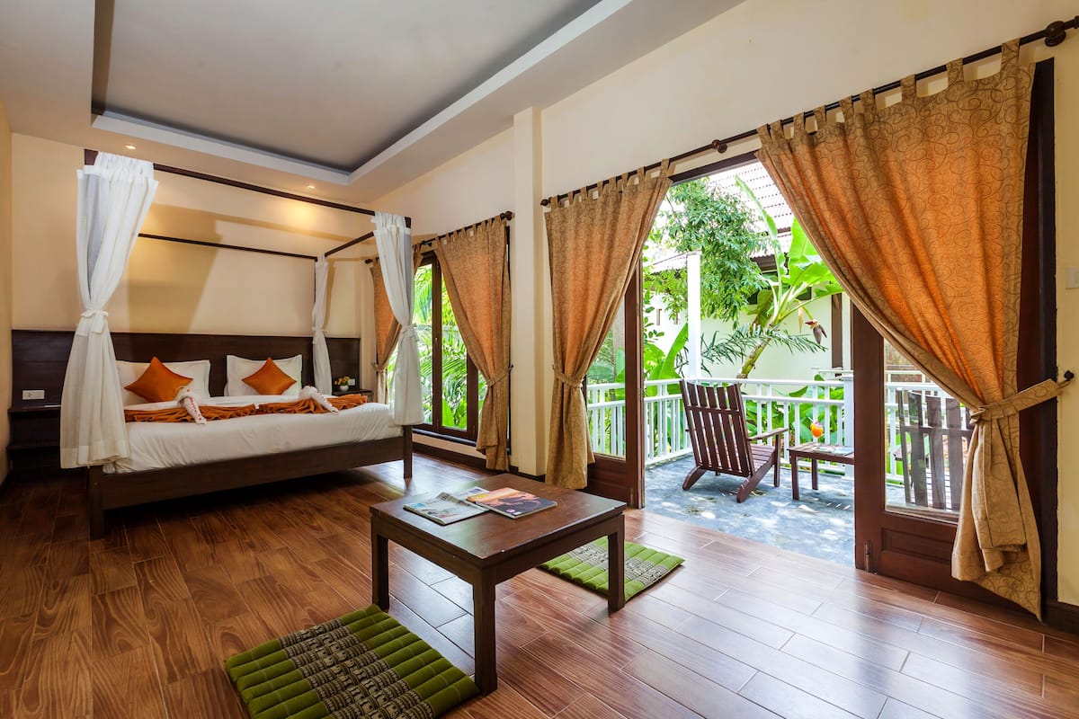 Um quarto com uma cama, uma mesa e cortinas.