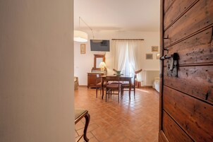 Uma área de refeições com uma mesa e cadeiras de madeira, uma luminária e um radiador.