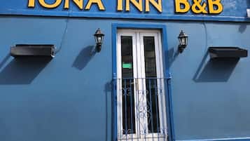 Um edifício com fachada azul e uma placa indicando 'IONA INN B&B'.