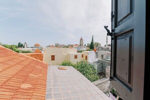 Vista da janela com uma paisagem urbana, incluindo edifícios históricos, uma torre e estruturas em cúpula.