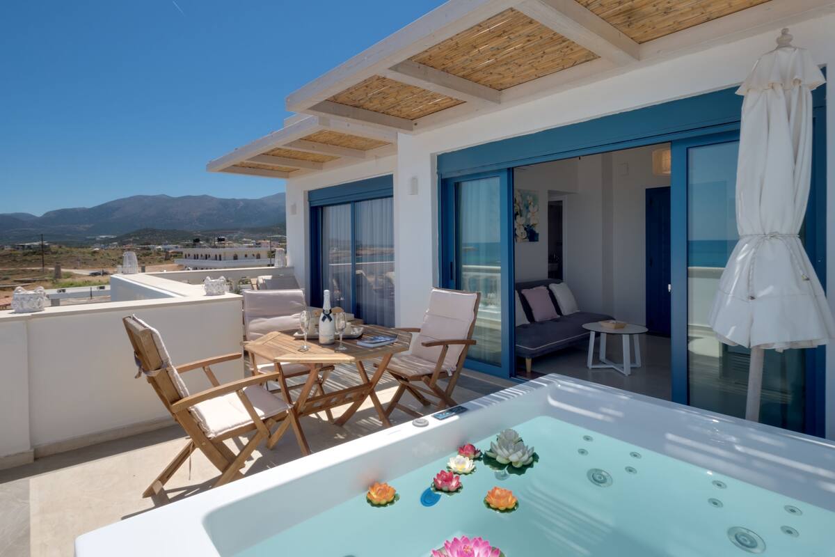 Terraço moderno ao ar livre com hidromassagem, área de estar e vista para a paisagem.