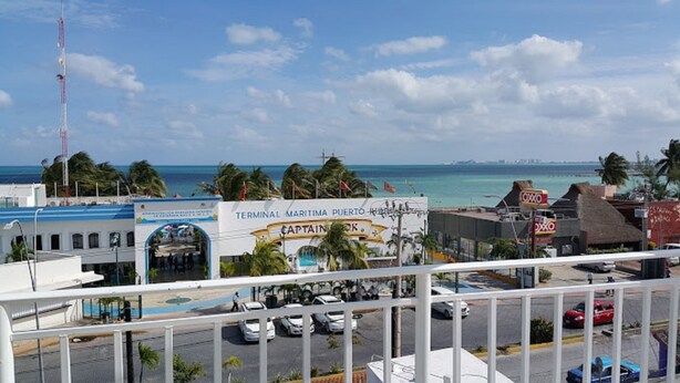 A coastal view with a prominent building labeled "TERMINAL MARITIMA PUERTO RICO" and "CAPTAIN'S MARK".
