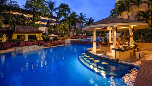Uma área de piscina com espreguiçadeiras e um bar.