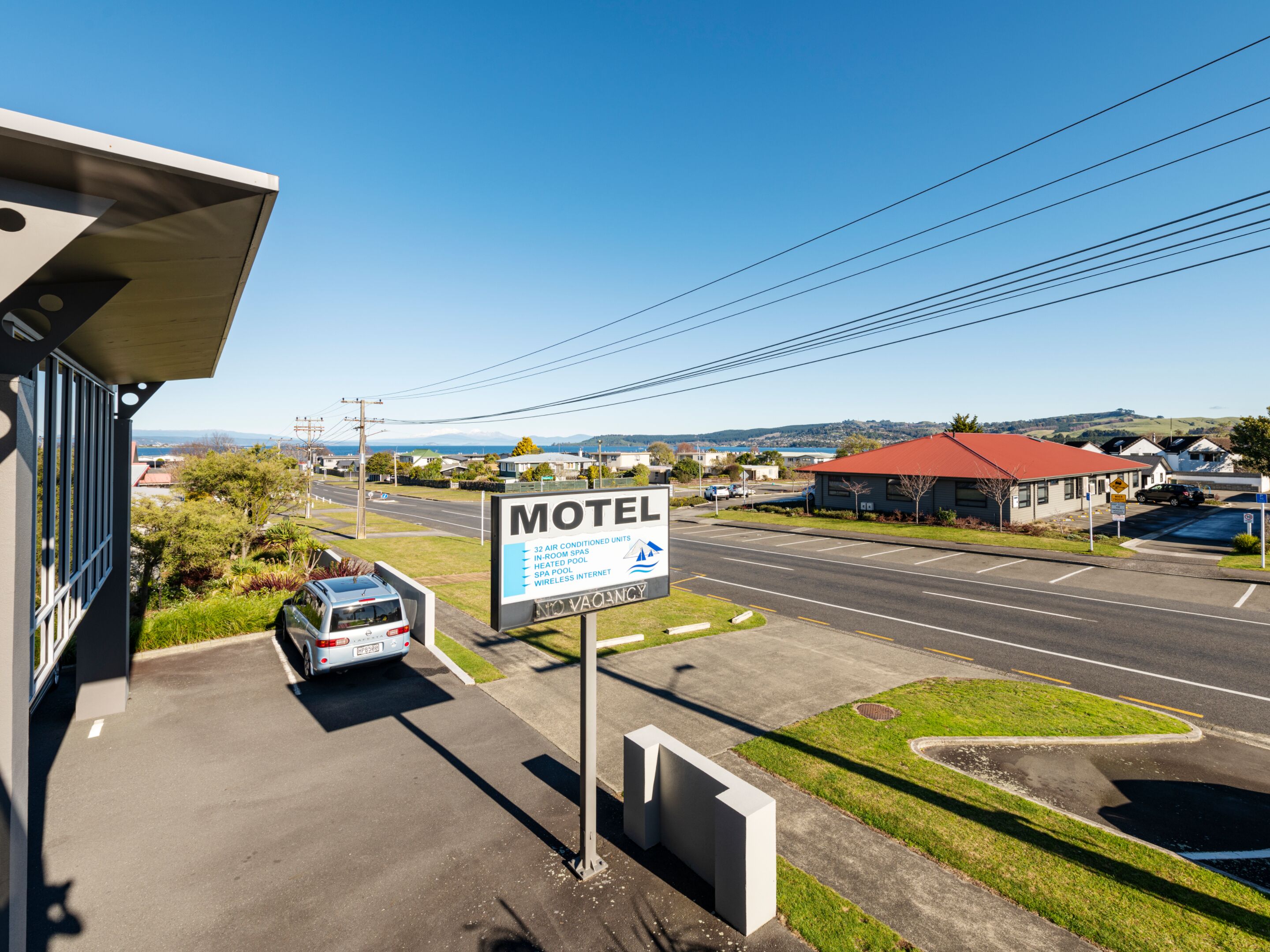 Um motel com uma placa que lista comodidades como quartos com ar condicionado, hidromassagens nos quartos e piscina.
