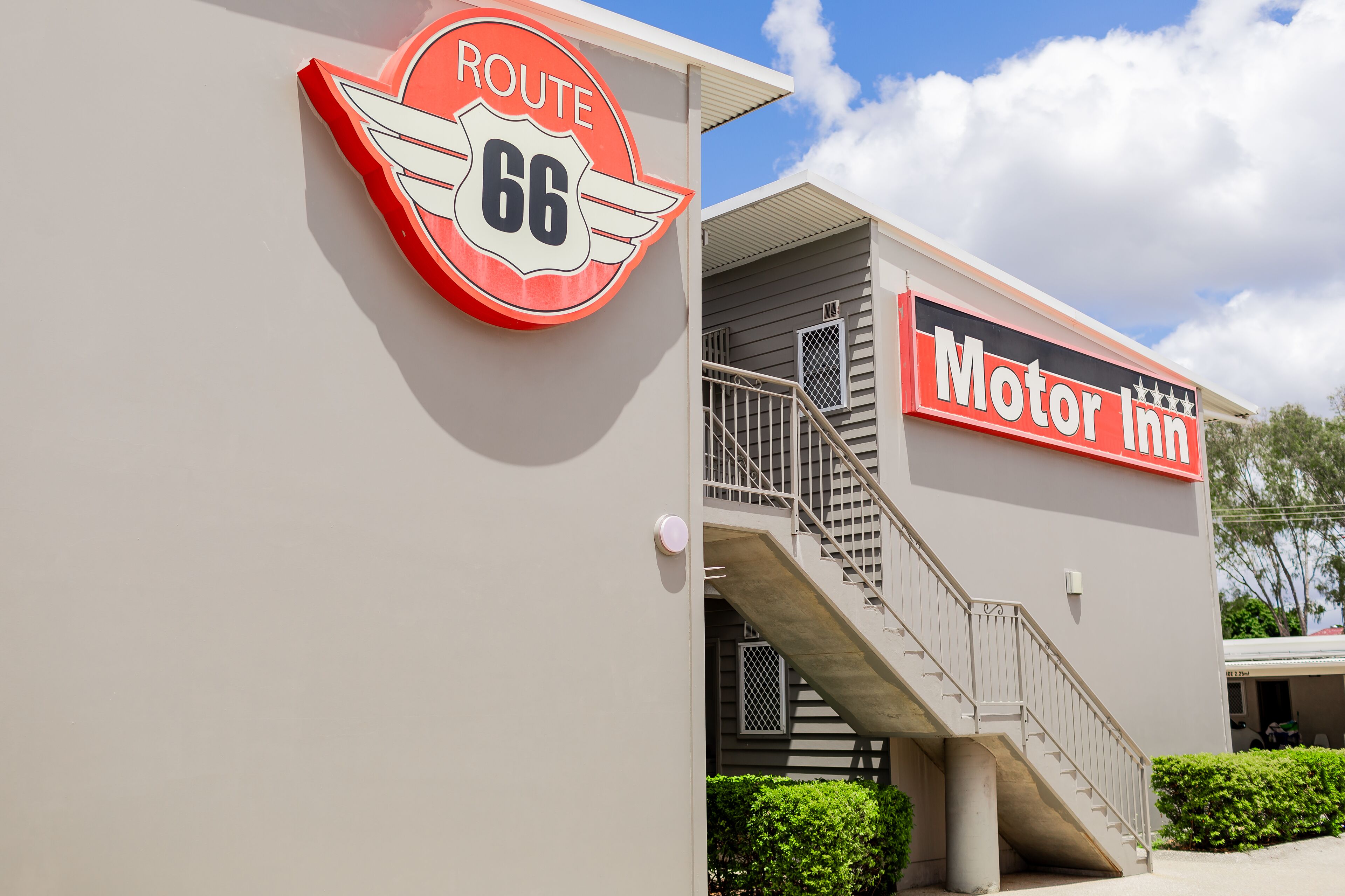 Um edifício com uma placa indicando 'Motor Inn' e o emblema 'Route 66'.