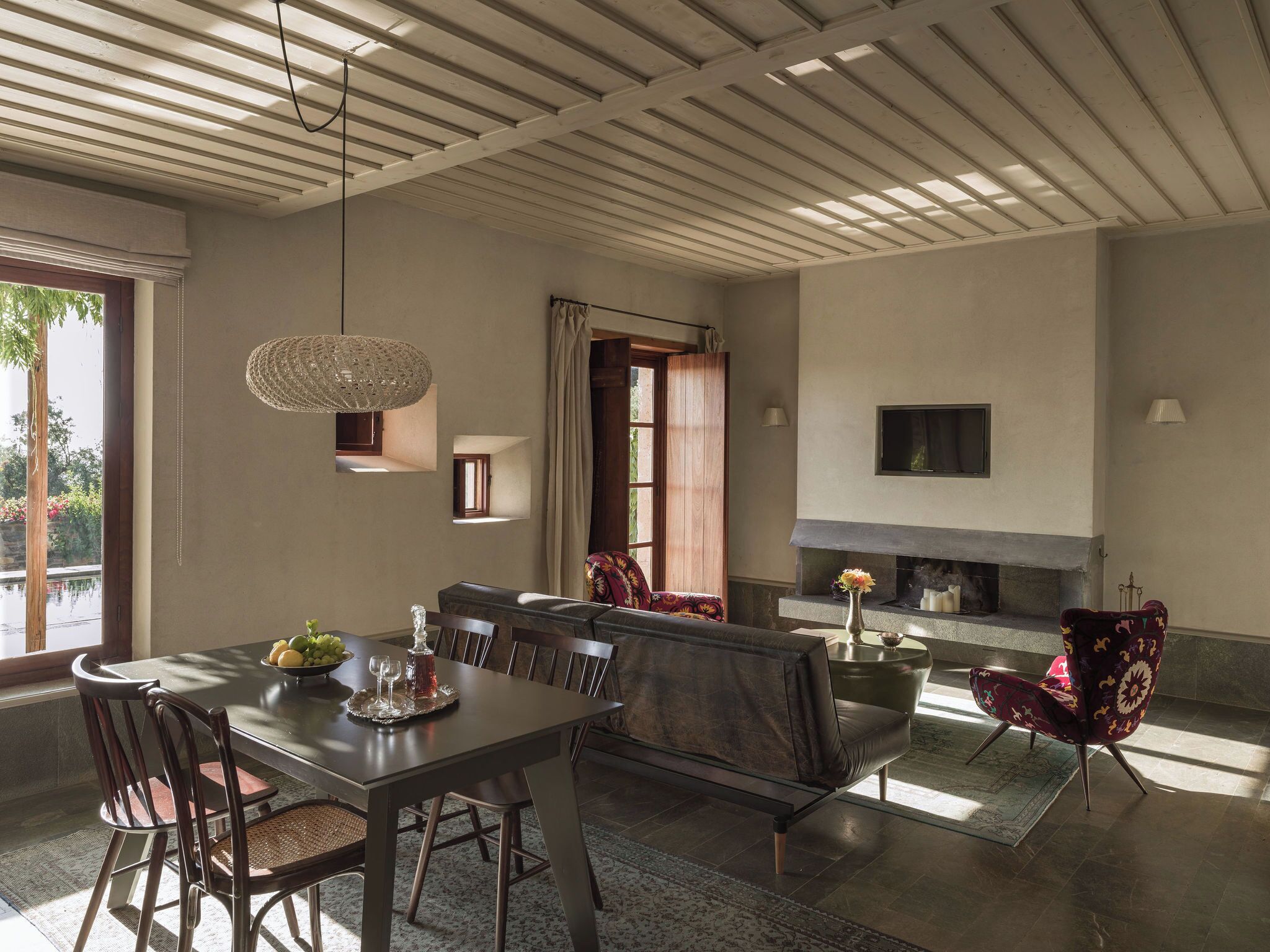 Uma área de refeições com mesa, cadeiras e lareira.