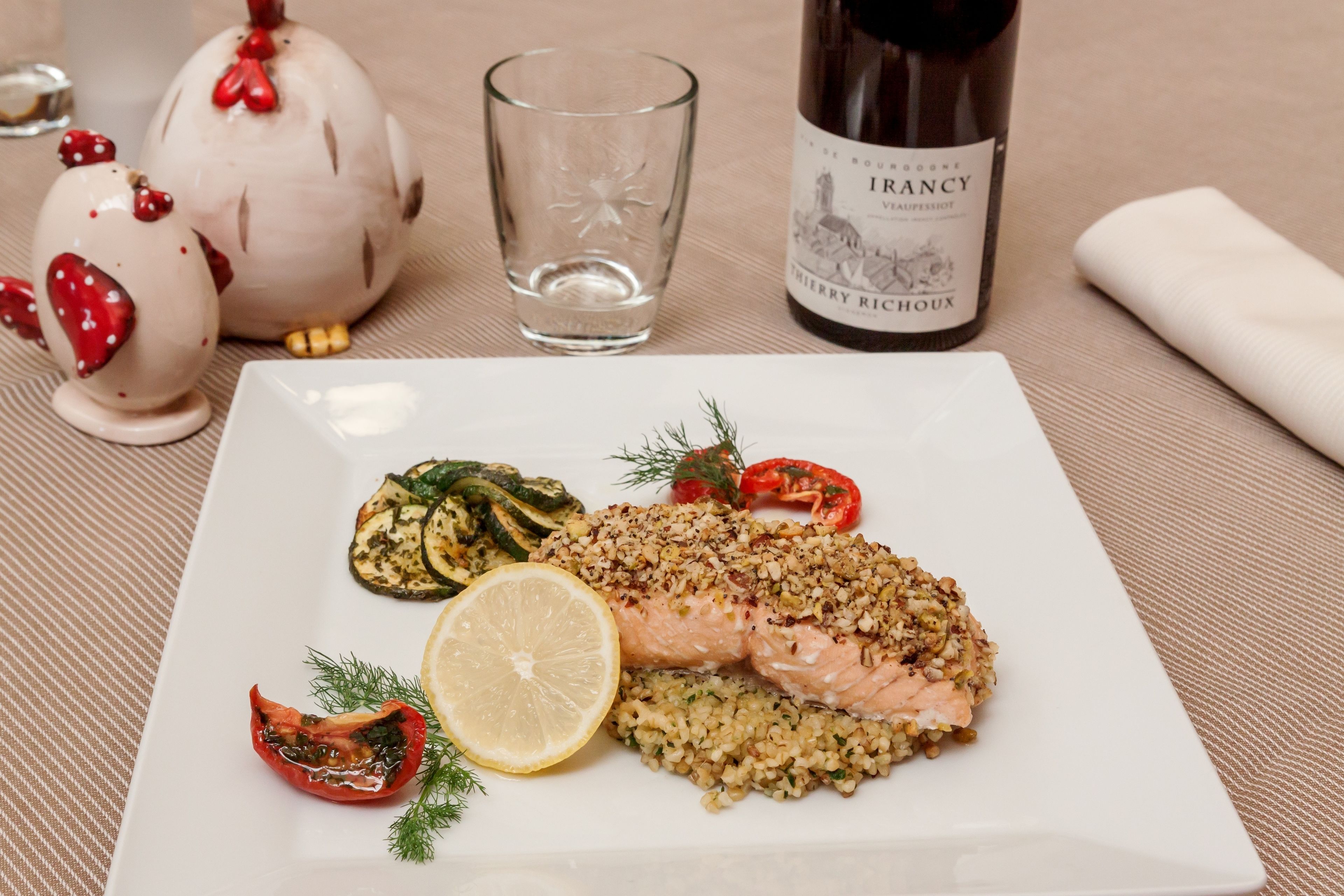 Um prato com salmão, legumes e uma fatia de limão.