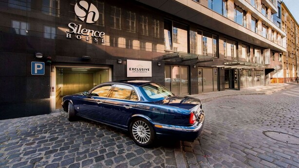 Um edifício com uma placa que diz “Silence House” e “APARTAMENTOS EXCLUSIVOS.”