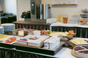 Buffet com diversas opções de comida e bebida.