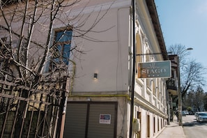 Um edifício com uma placa indicando 'SIAGO' e uma porta de garagem fechada com uma placa de proibido estacionar.