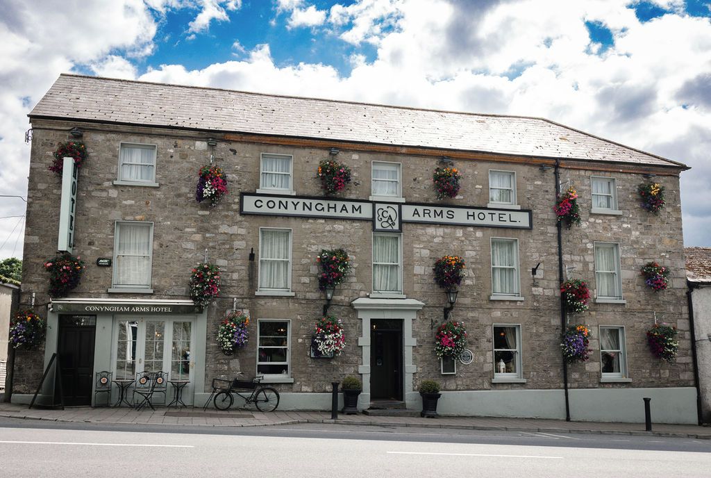 Um edifício de dois andares com uma placa indicando 'Conyngham Arms Hotel'.