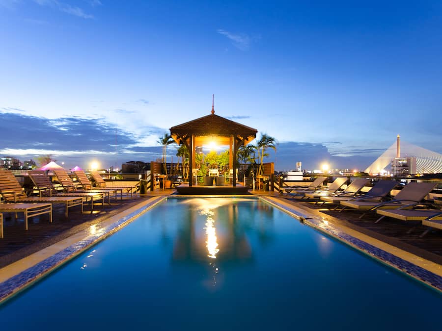 Uma área de piscina com espreguiçadeiras e um gazebo.