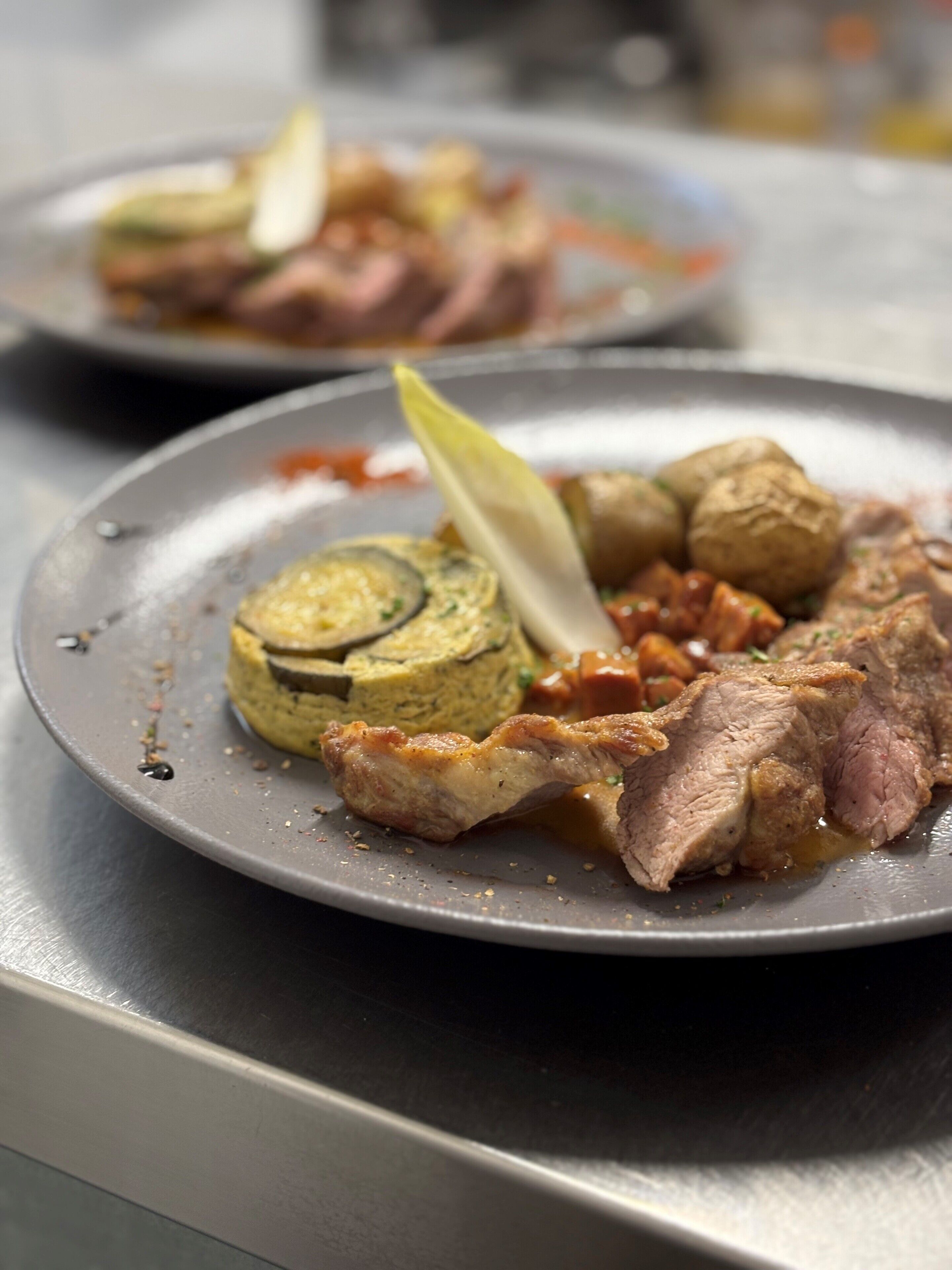 Um prato com fatias de carne, um legume arredondado e um enfeite de folhas.