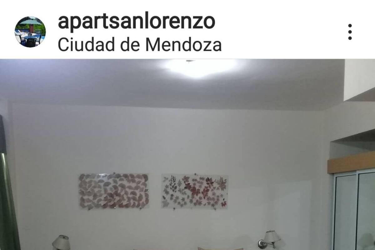 Quarto com uma cama, duas mesas de cabeceira, uma mesa e cadeiras.