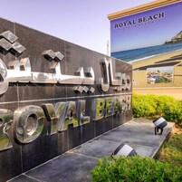 Placa do Royal Beach Hotel & Resort com escrita árabe e texto em inglês.