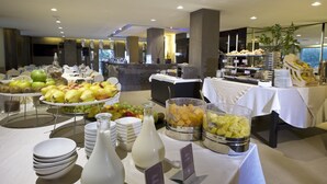 Buffet com diversas frutas e bebidas, incluindo maçãs, peras e uma garrafa de leite.