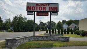 Placa do Budget Motor Inn com aviso de quarto disponível.
