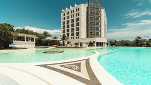 Um hotel com piscina, área coberta e edifício de vários andares.