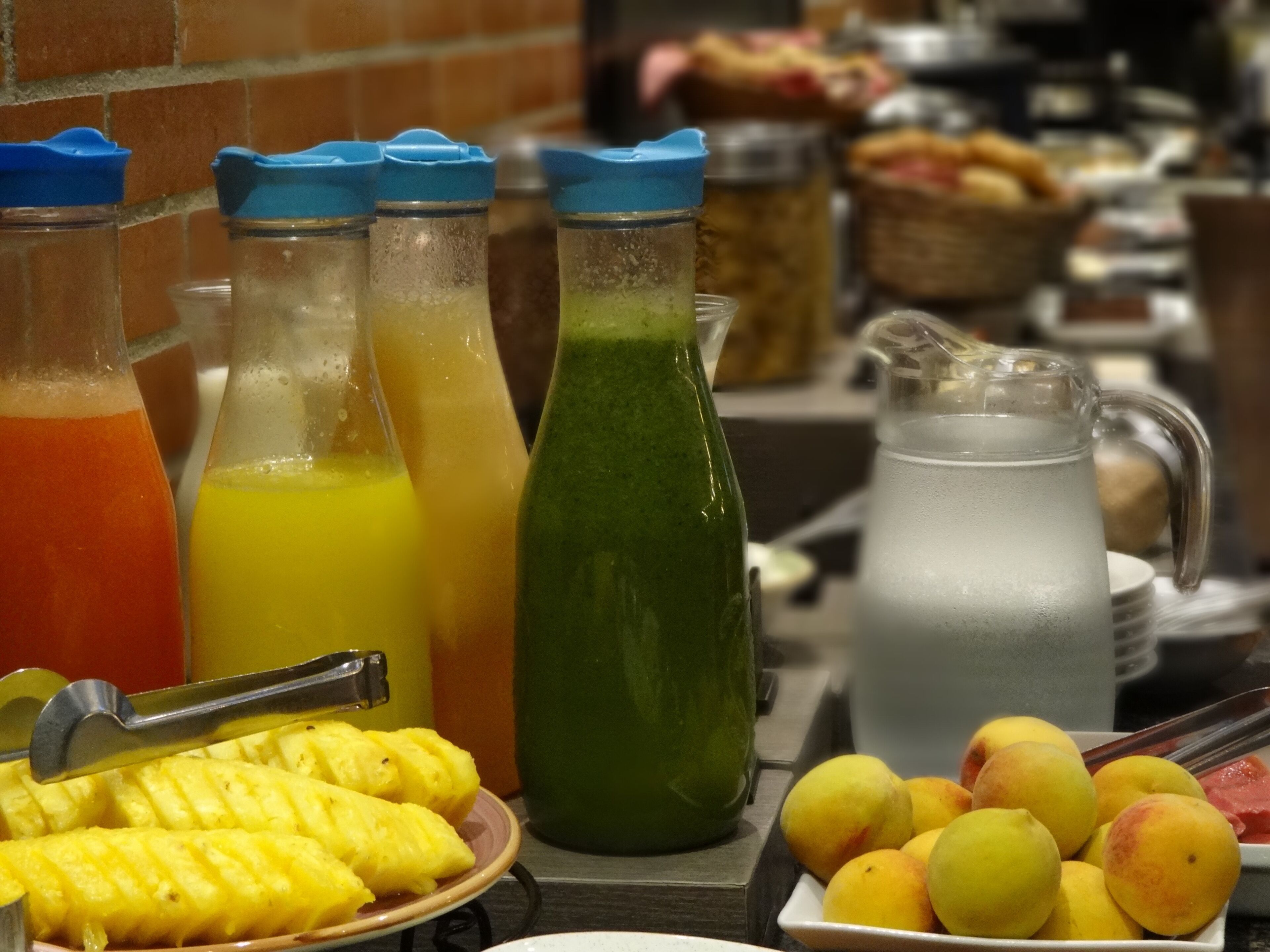 Um buffet de café da manhã com diversas bebidas e frutas.