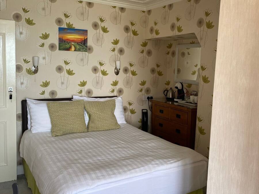Quarto com cama, penteadeira, espelho e ventilador de teto.