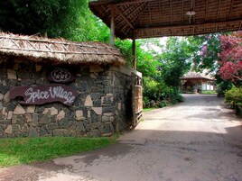 Mural de pedra com um letreiro que diz 'Spice Village' e uma construção de telhado de palha.