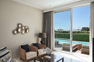 Uma sala de estar moderna com uma porta de vidro que dá para uma área de piscina.