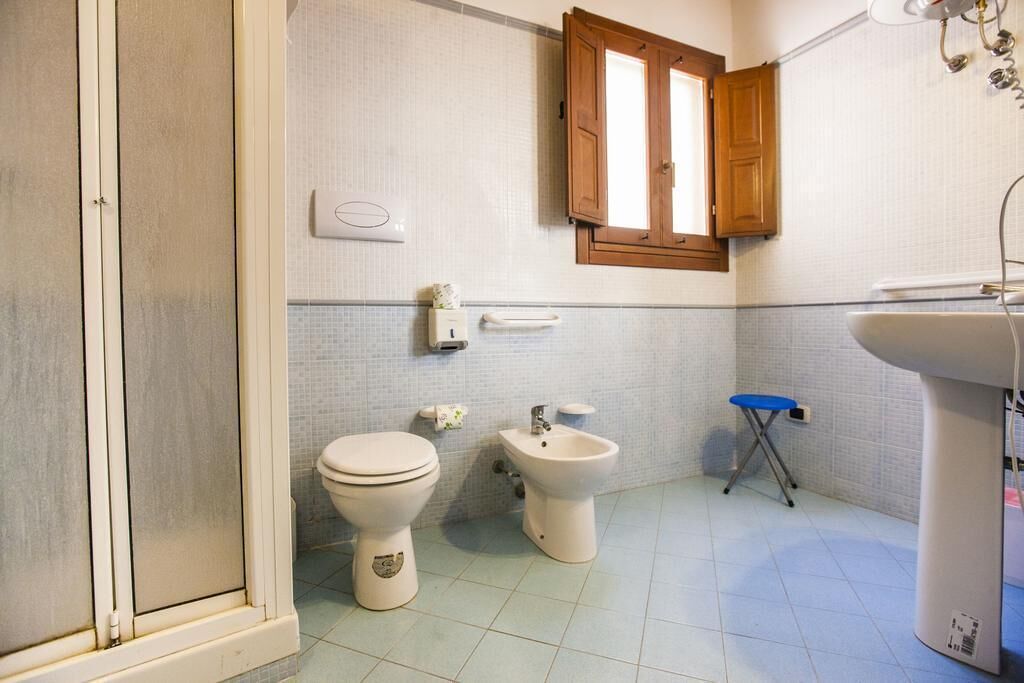 Uma casa de banho com sanita, bidé e lavatório.