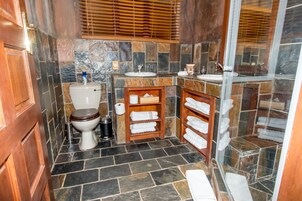 Casa de banho com sanita, lavatório e chuveiro.