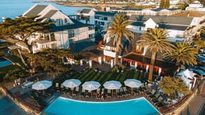 Um resort com piscina, área de estar ao ar livre e palmeiras.