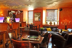 Um espaço de bar acolhedor com poltronas de couro, um jogo de dardos e um balcão.
