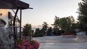 A entrada portão com vista para o mar, precedida por um caminho de acesso pavimentado.