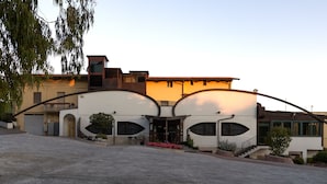Um edifício moderno com fachada curva, grandes janelas e área de entrada ampla.
