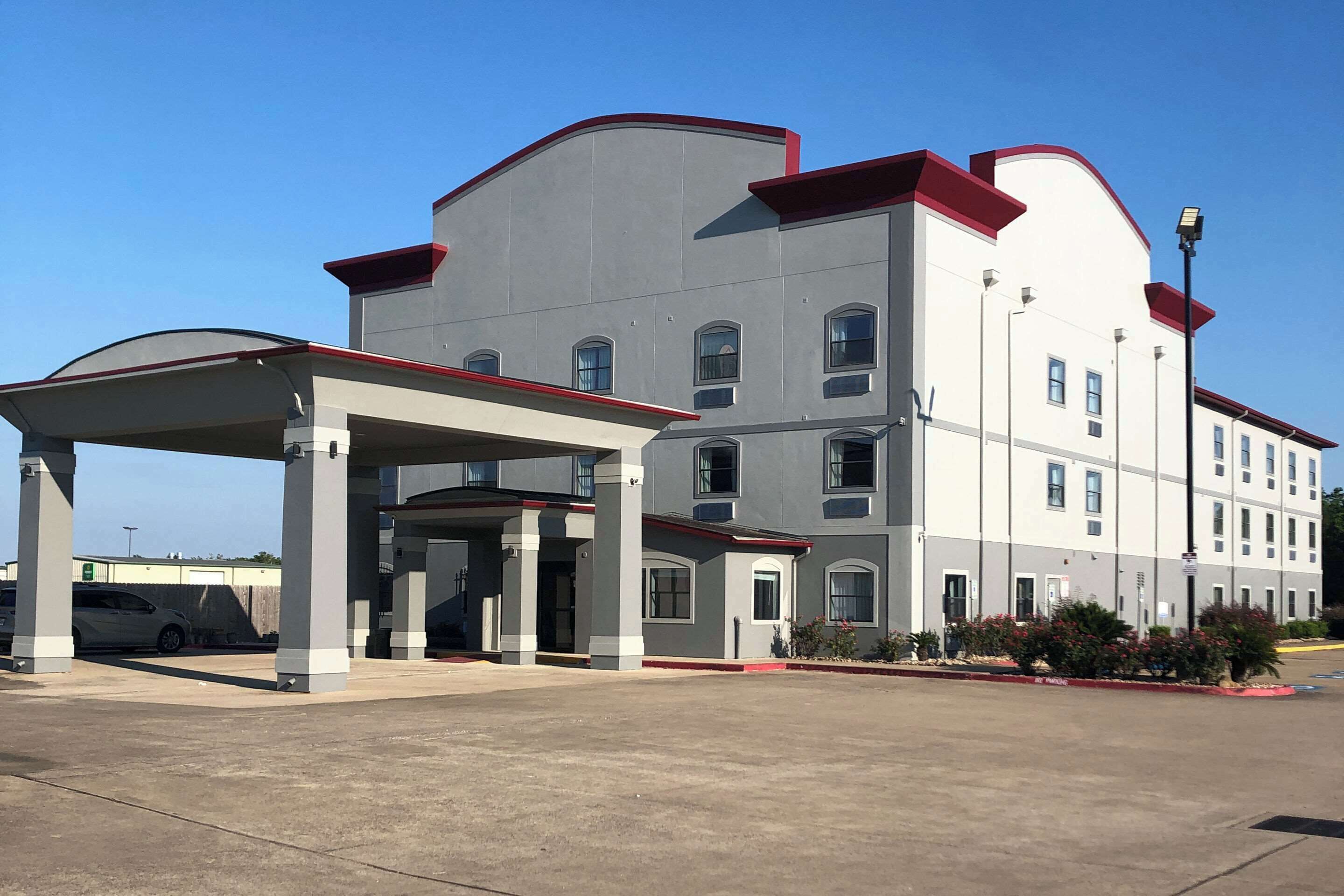 Um hotel com vários andares, área de estacionamento coberta e design arquitetônico moderno.
