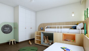 Quarto de criança com beliche, uma pequena escrivaninha e um tapete verde no chão.