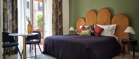 Quarto de hotel com uma cama, uma mesa redonda e uma cadeira.