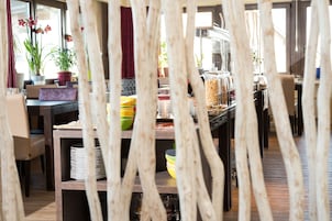 Espaço de buffet com diversas opções de comida e área de estar com vista para o exterior.