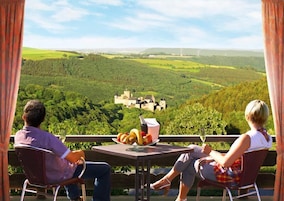 Duas pessoas sentadas à mesa com vista para um castelo ao longe.