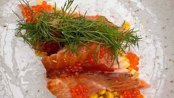 Um prato com salmão, caviar, grãos de milho e endro.