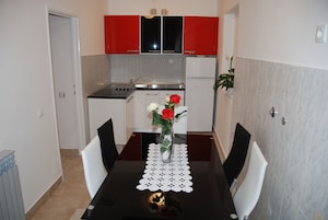 Uma mesa de jantar com toalha de renda, um vaso com flores e um centro de mesa preto.